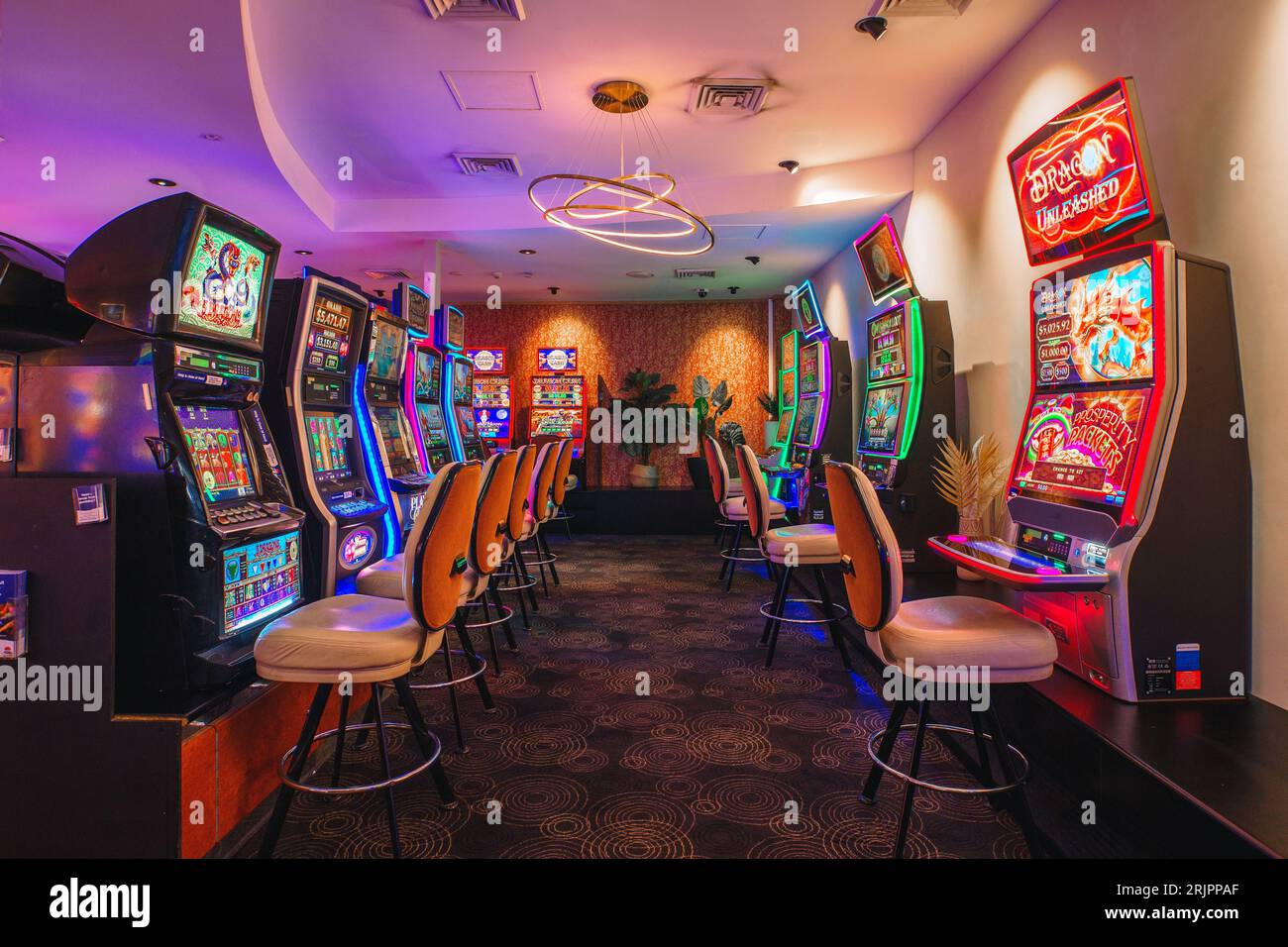 A modern arcade room filled with colorful machines and seating Stock ...