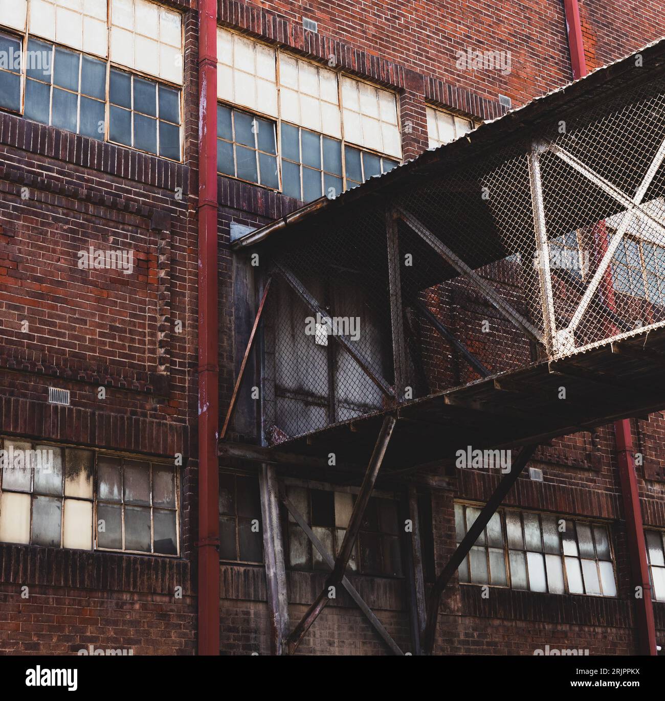 A close-up of an old metal bridge leading to a brick building in an ...