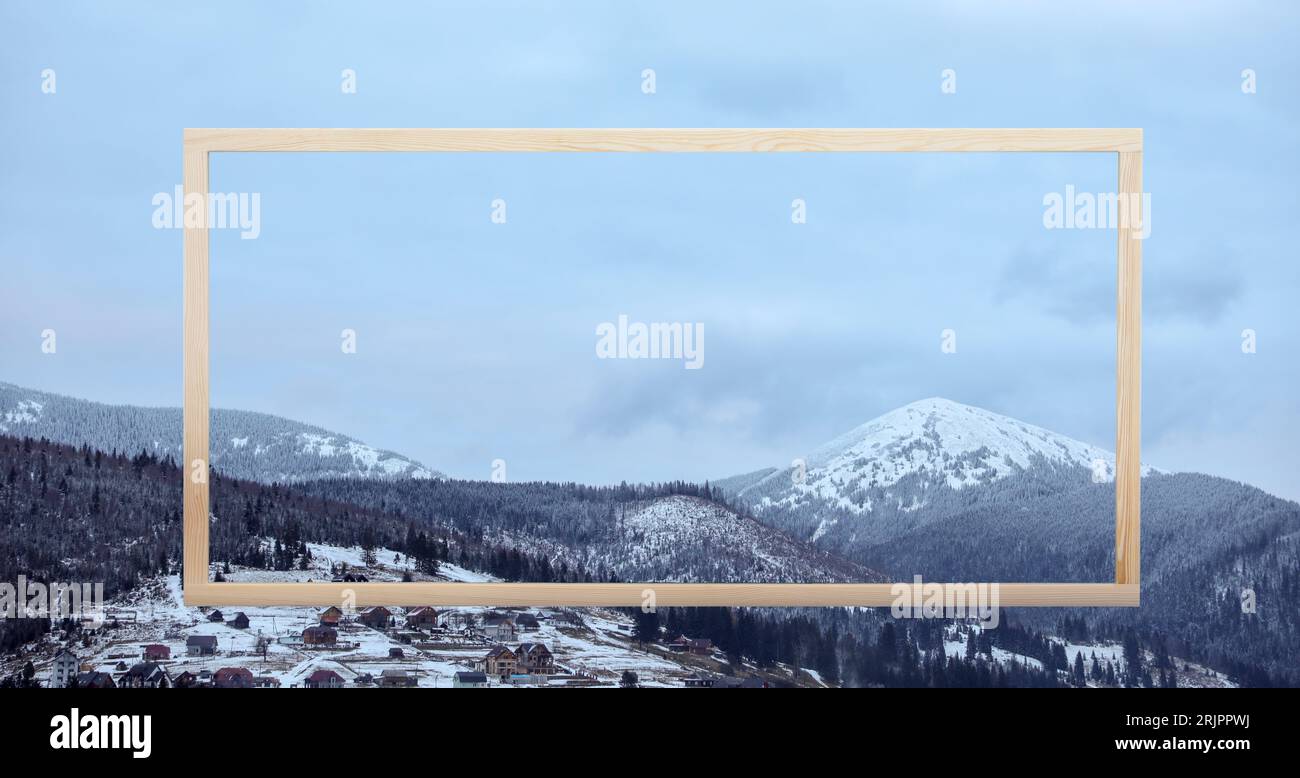 Wooden frame and beautiful mountains covered with snow in winter ...