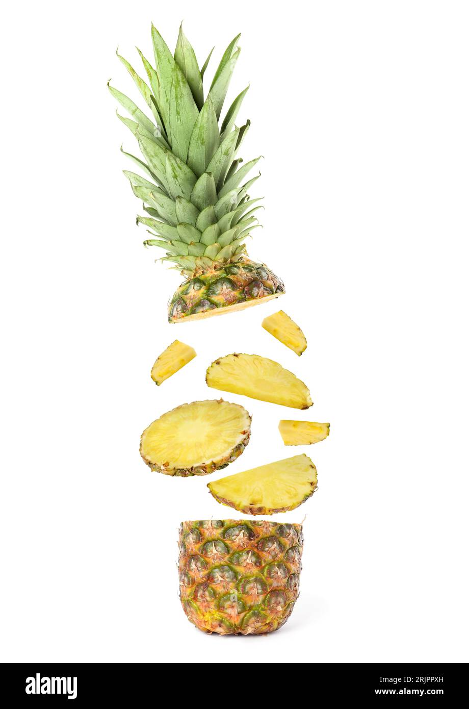 Slices of juicy pineapple flying between its top and bottom on white ...