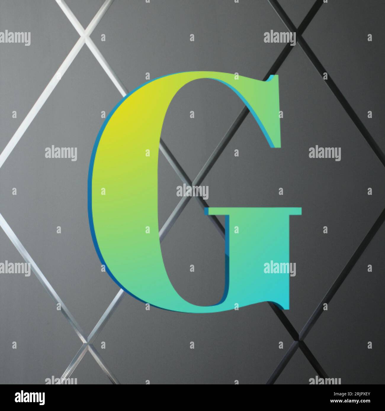 A glowing letter G illuminated against a gray wall with an ornamental ...