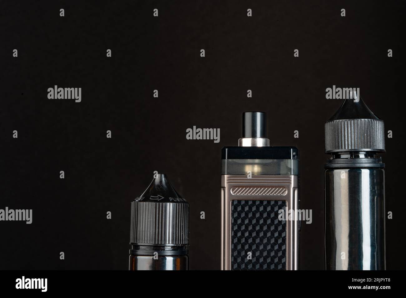 Vape and vape liquid bottles against black background Stock Photo - Alamy