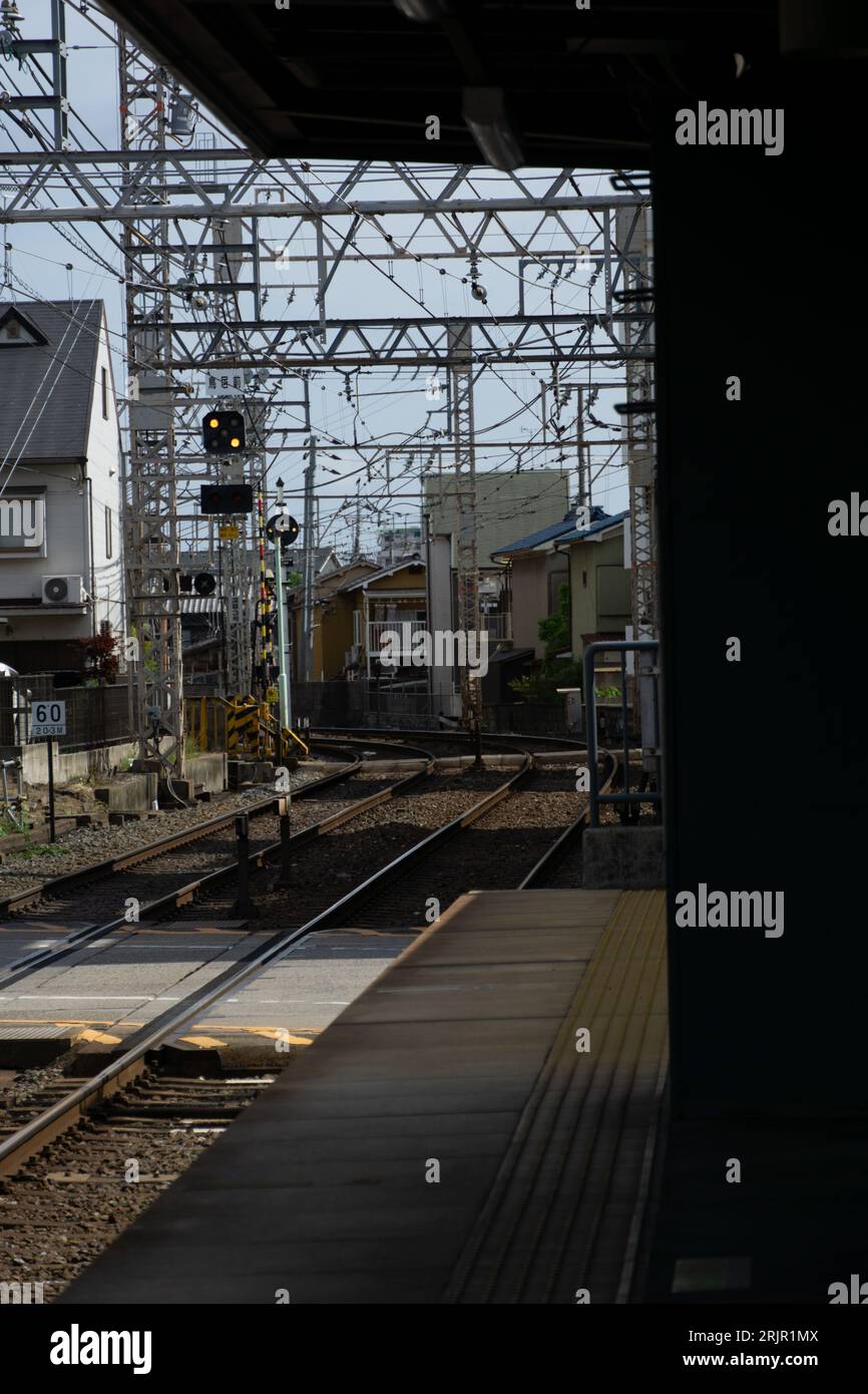 A busy train station platform with train tracks in the background Stock ...