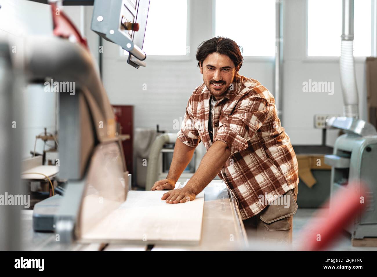 Male carpenter using some woodworking tools for his work in a factory ...