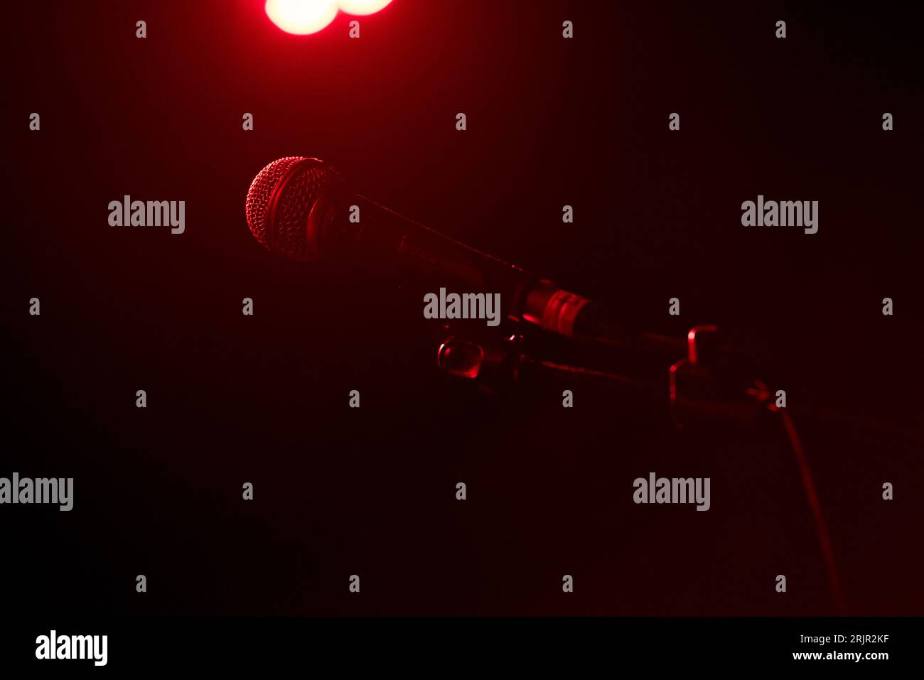 A closeup of a microphone in a dim concert venue Stock Photo - Alamy