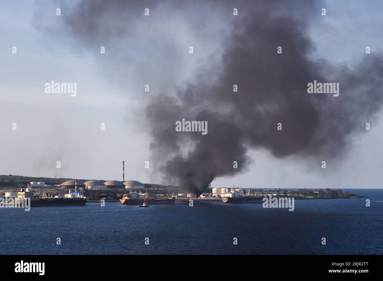 An industrial harbor with many vessels and black smoke rising Stock ...