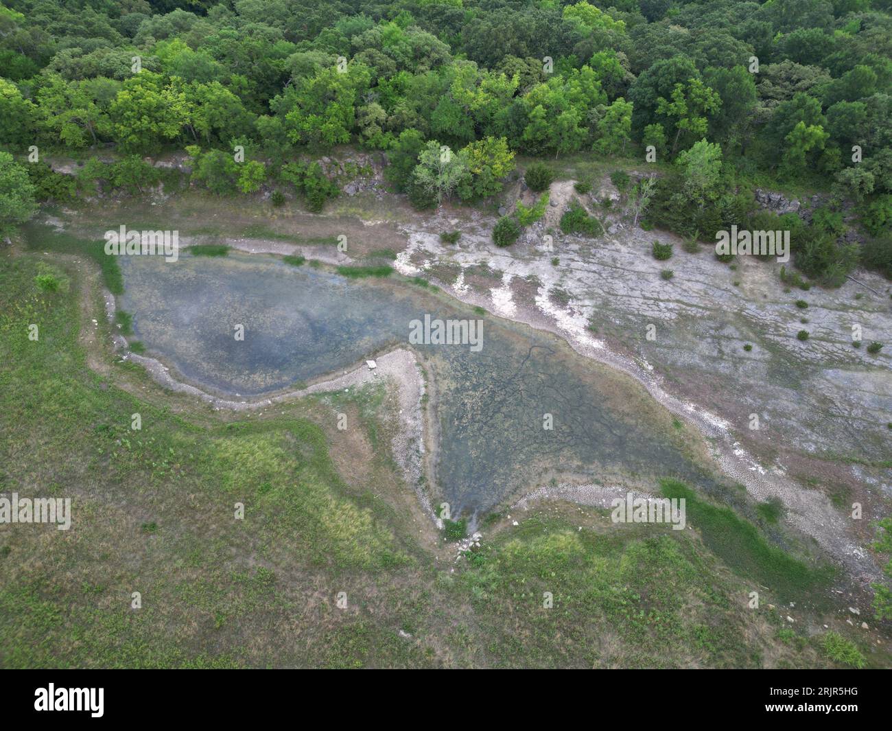 An aerial view of a pond in an expansive grassy field Stock Photo - Alamy
