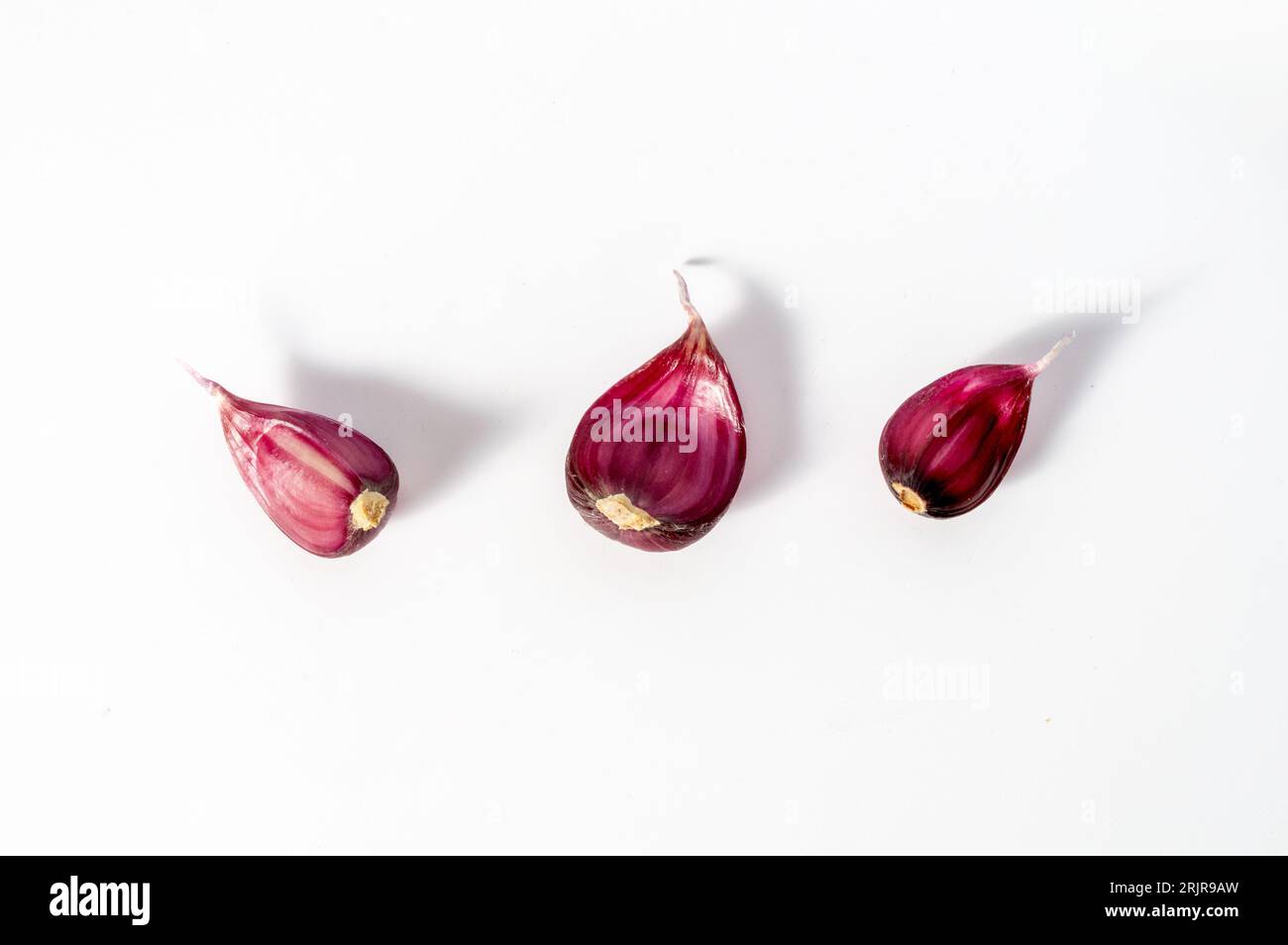 Purple garlic clove on a white background Stock Photo - Alamy