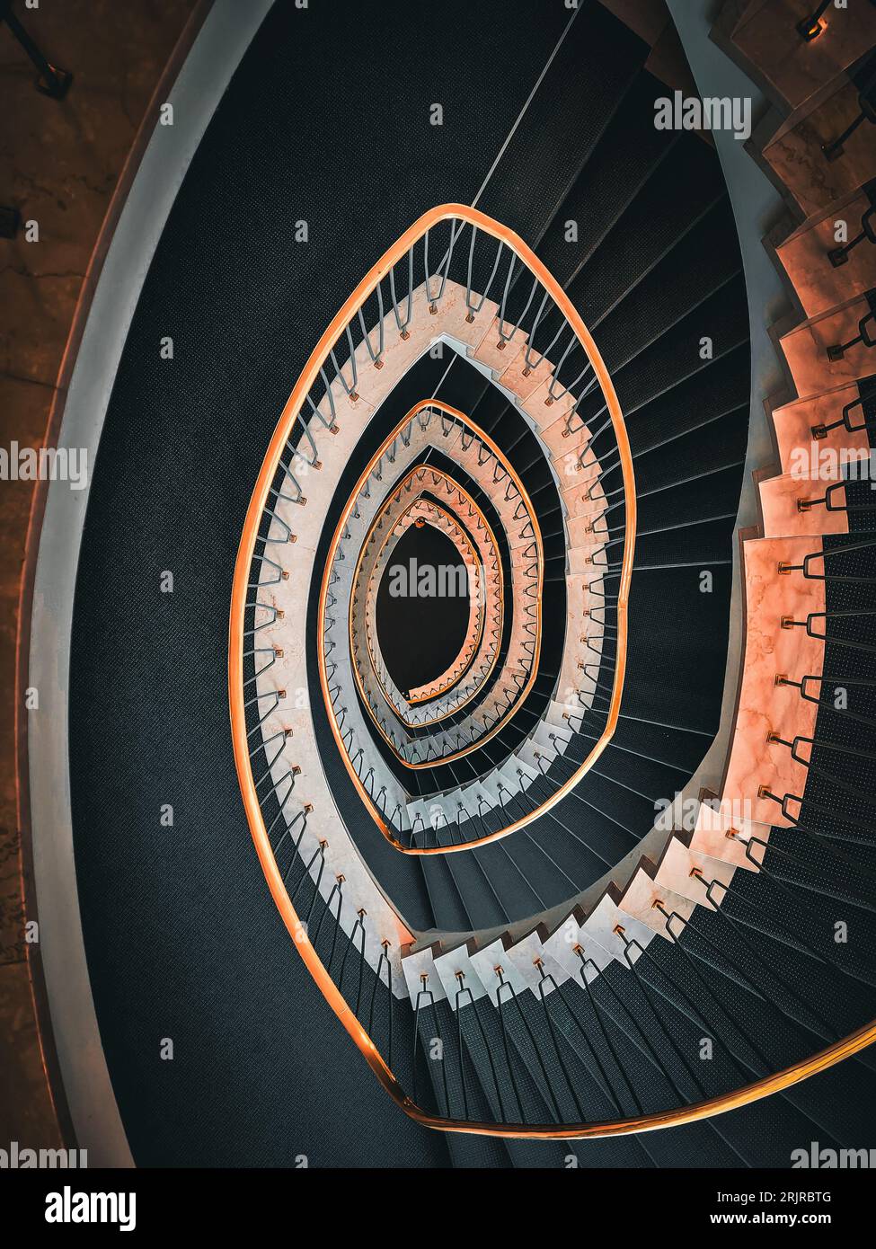 An elevated view of a modern spiral staircase with black stairs and a ...