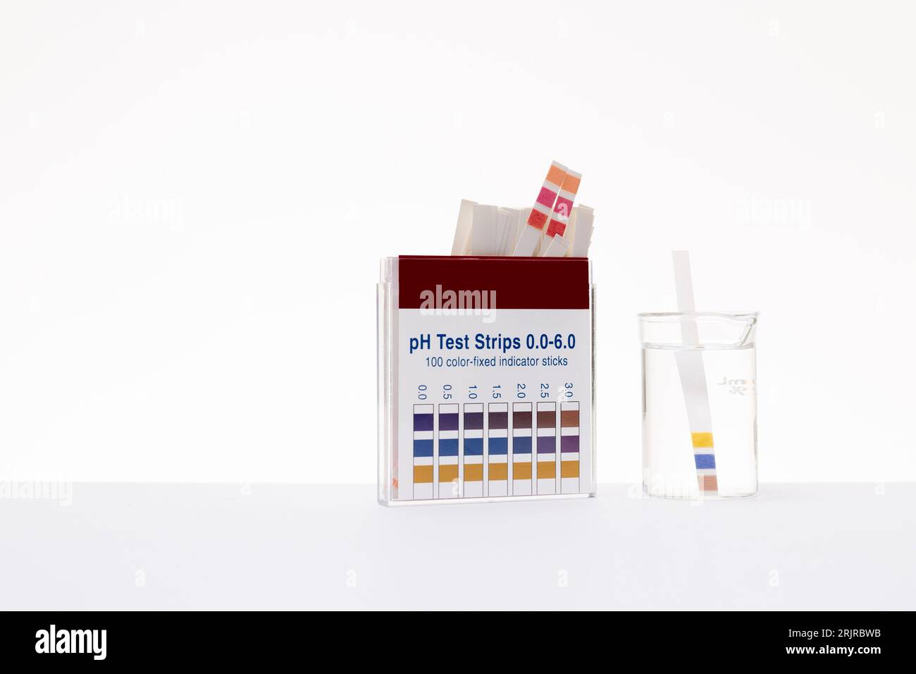 A white background with test strips for testing the pH level and a ...