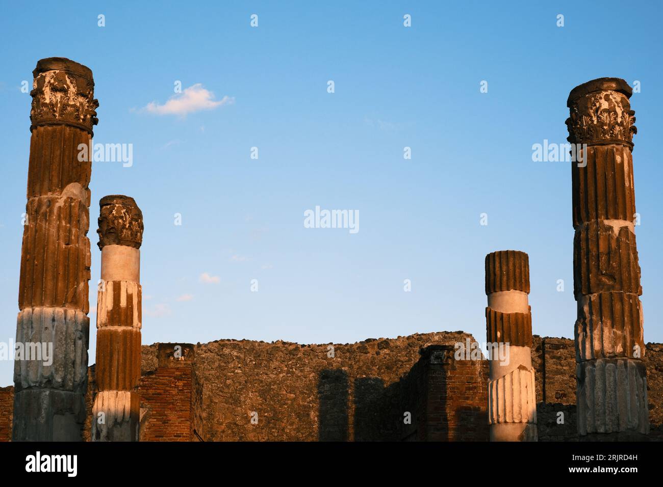 Two tall ancient ruins pillars stretching skyward into the cloudy sky ...