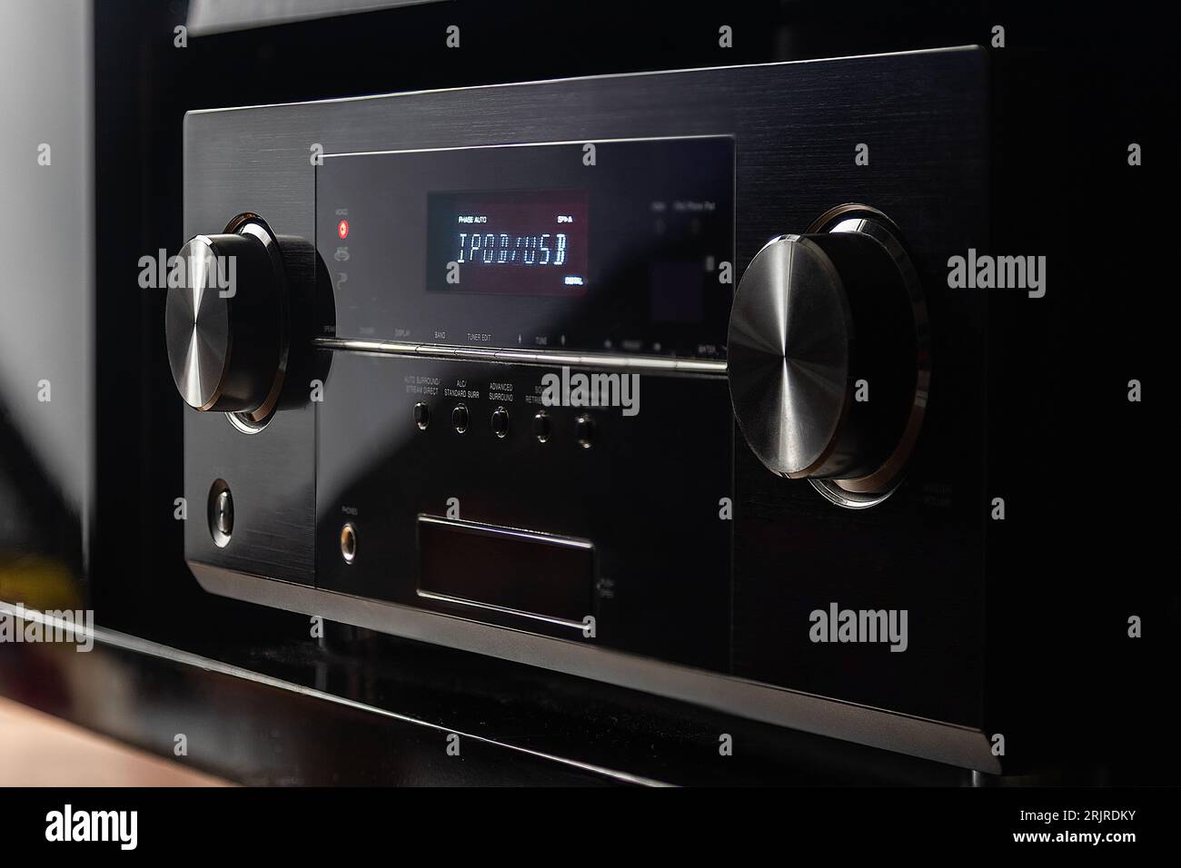 A modern, black audio video receiver with a glossy finish and ...