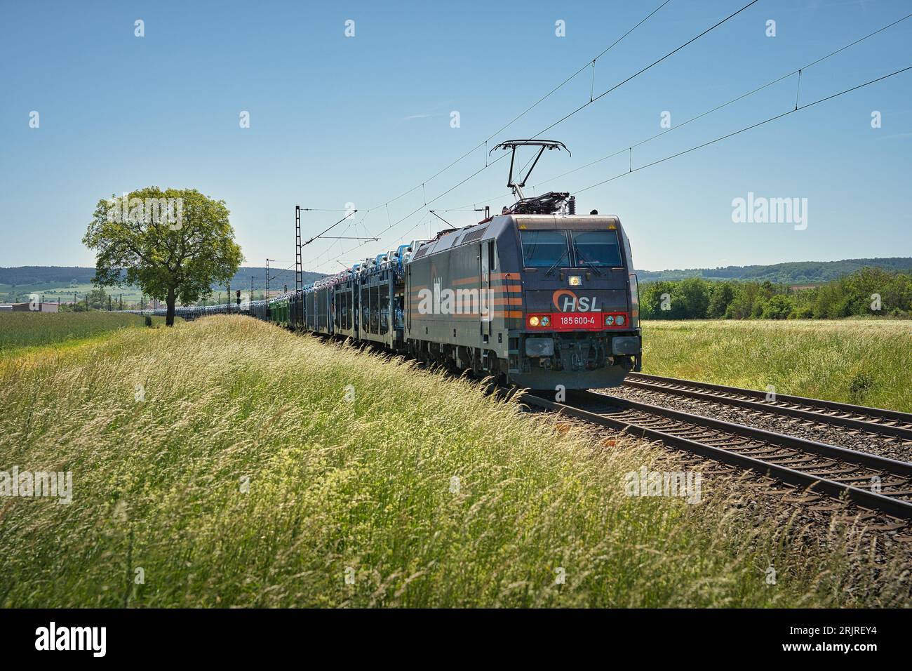 A passenger train chugging along the tracks in a rural setting with ...