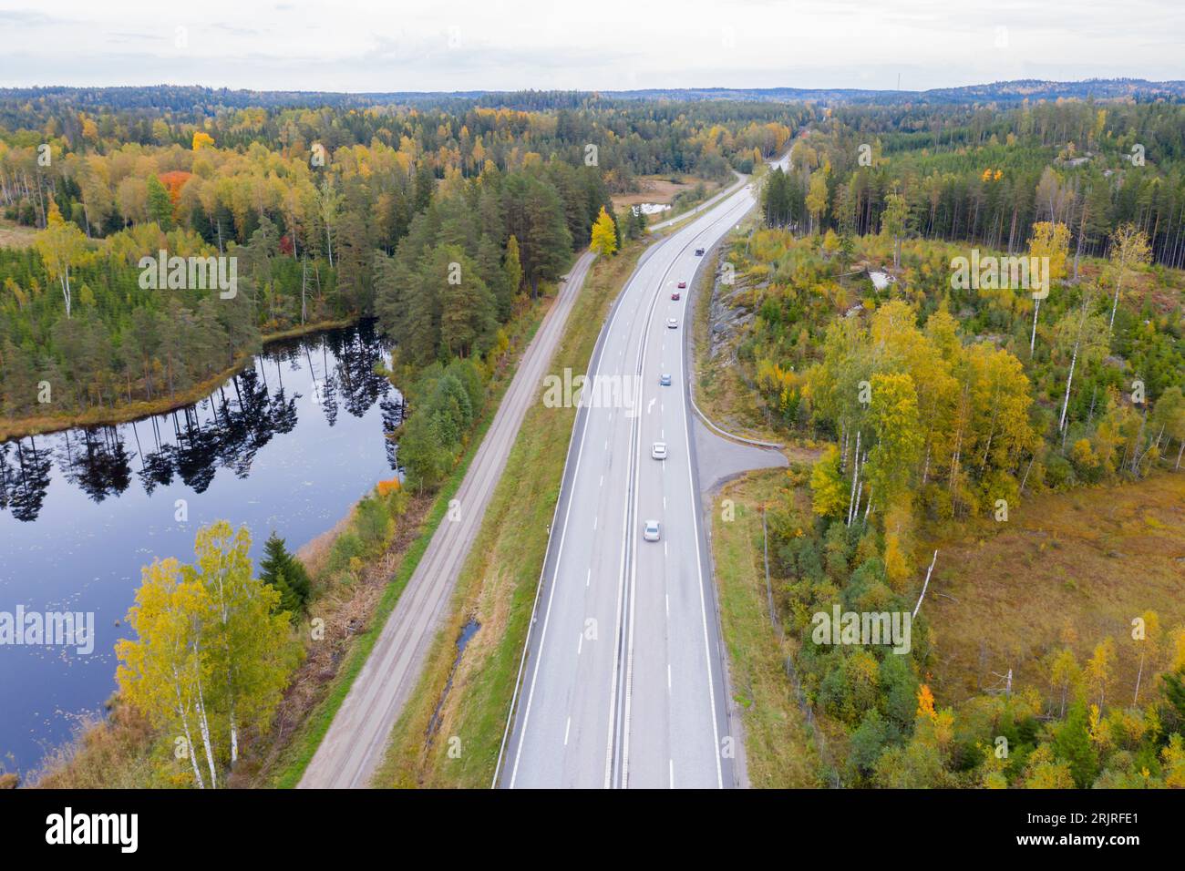 A scenic highway winding through lush green vegetation, with trees and ...