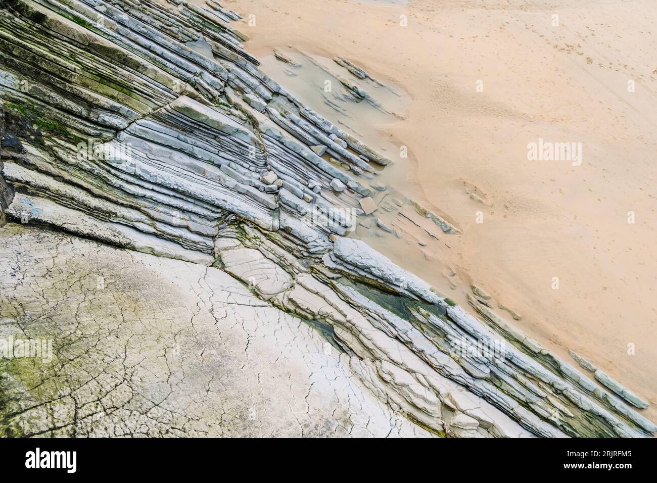 Flysch buried in the sand of a beach, beautiful geological background ...
