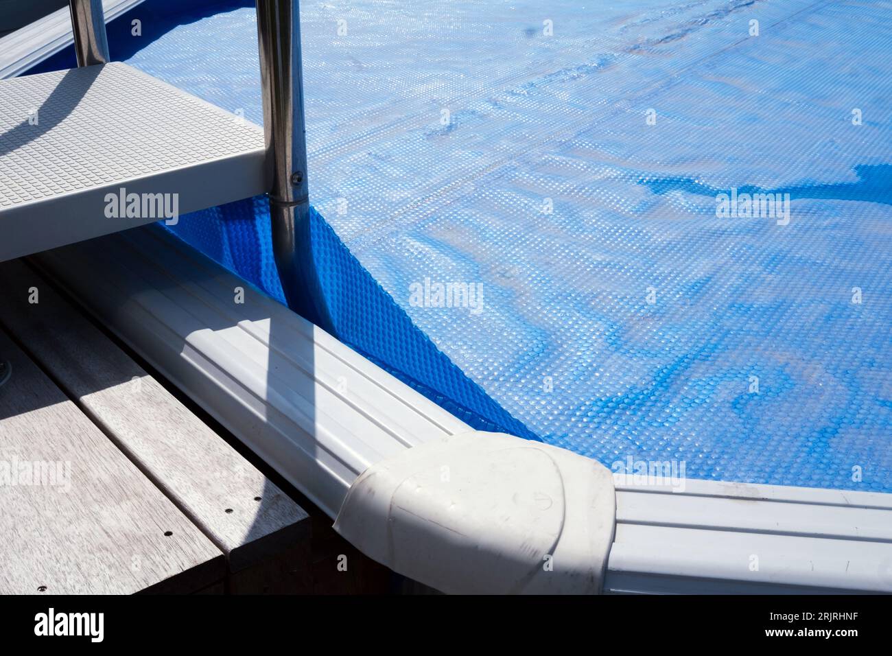 Detail of a portable pool, mounted in the backyard, decorated with wood ...