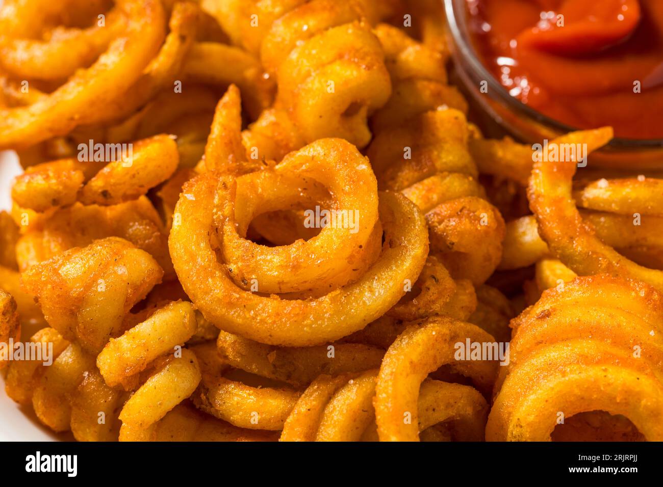 Seasoned Homemade Curly French Fries with Ketchup Stock Photo - Alamy