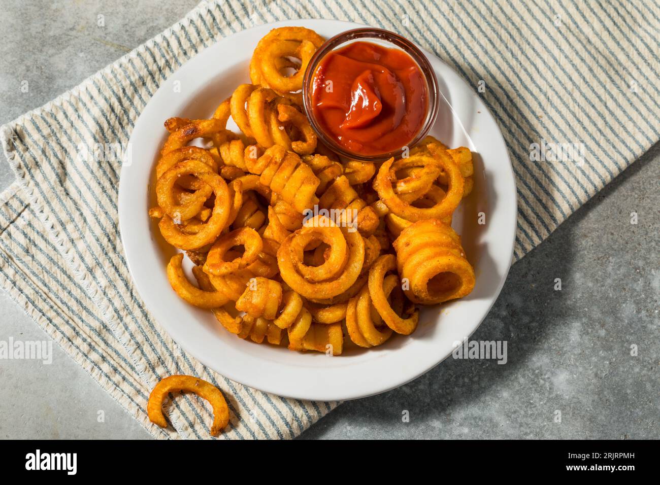 Seasoned Homemade Curly French Fries with Ketchup Stock Photo - Alamy