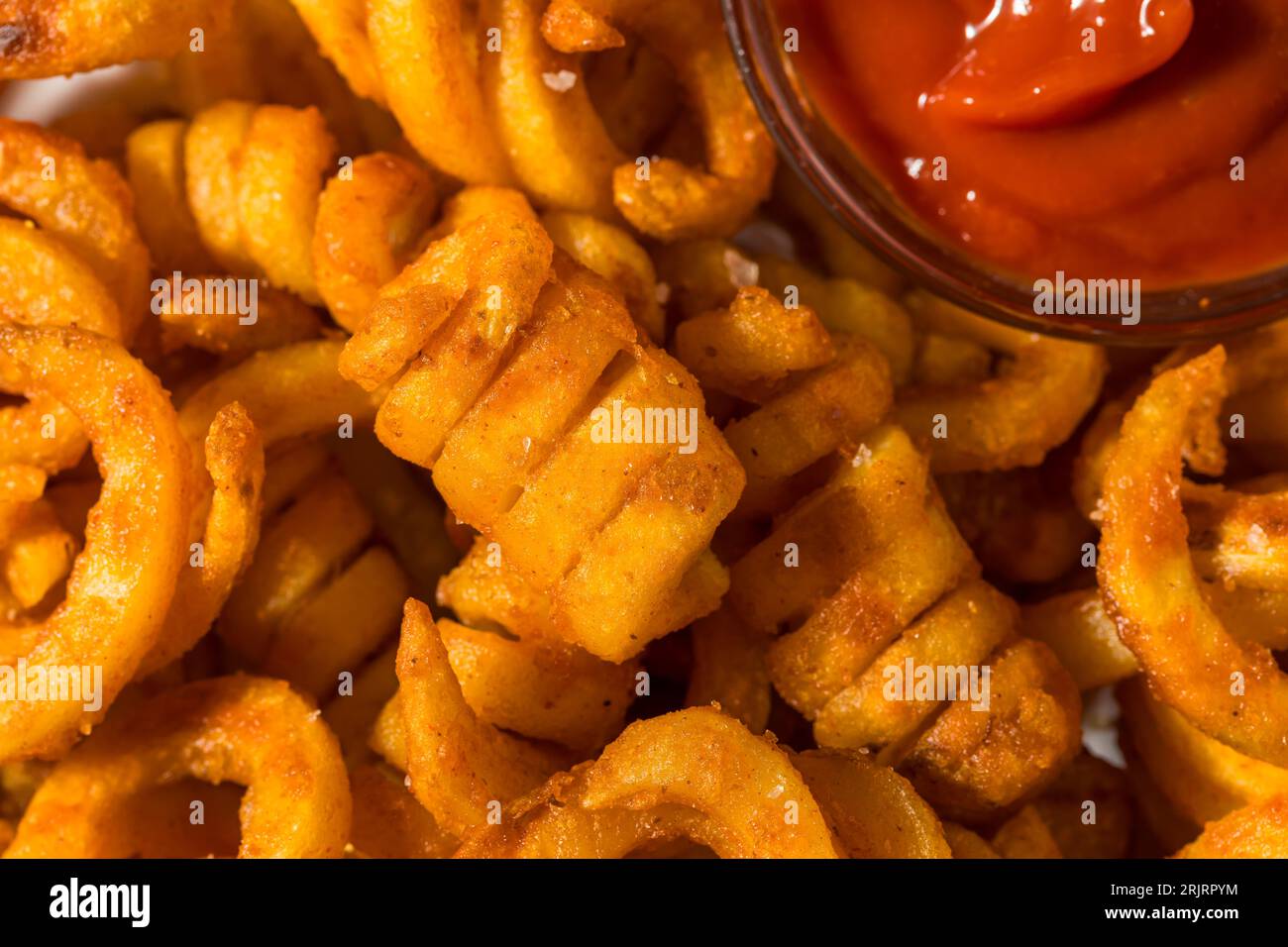 Seasoned Homemade Curly French Fries with Ketchup Stock Photo - Alamy