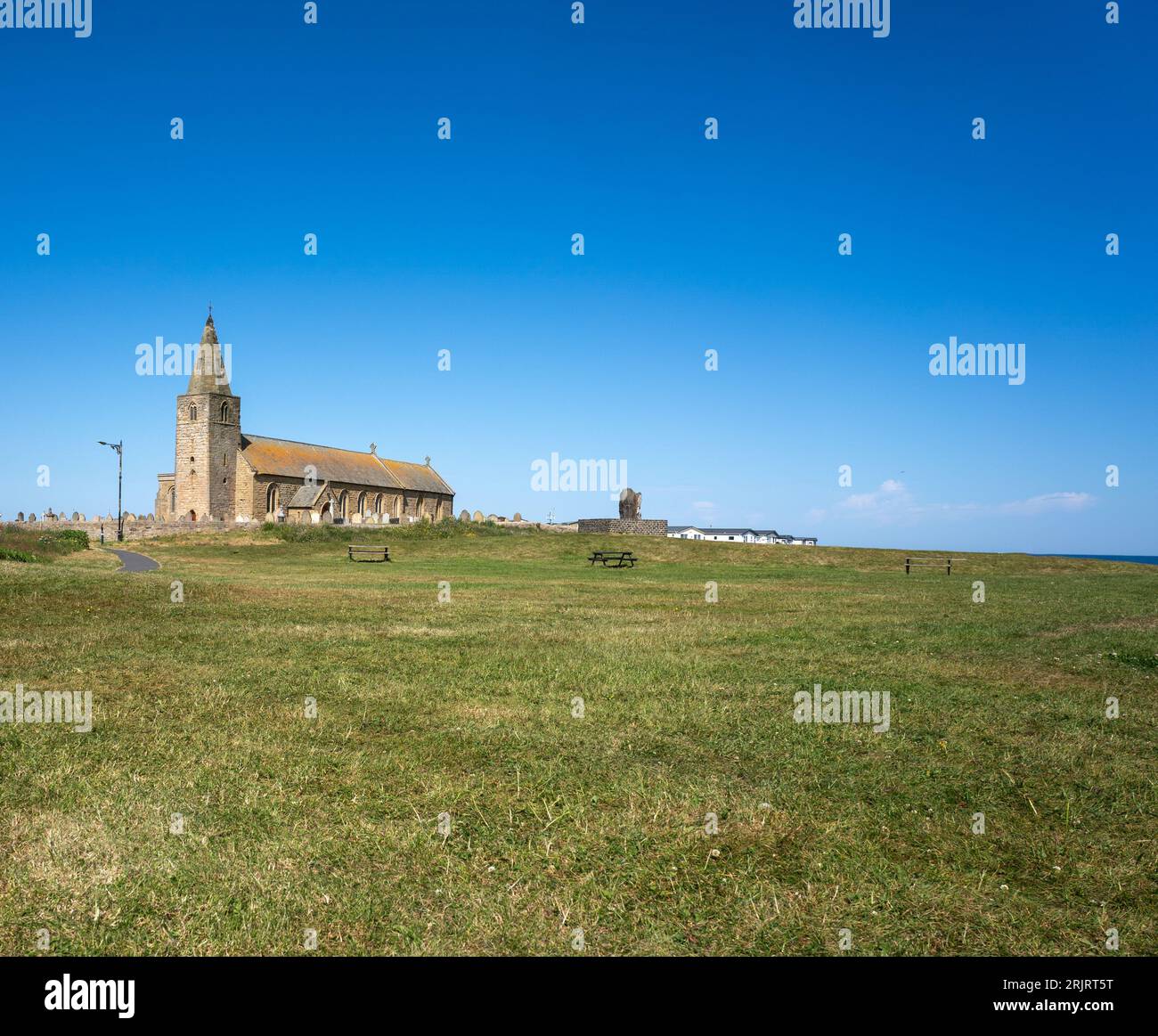 A traditional, old-style church stands in a vast grassy field against ...