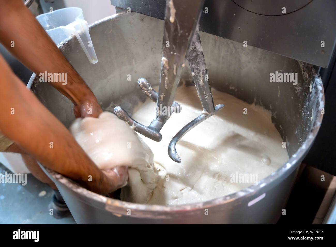 A baker kneading the flour in a mixer Stock Photo - Alamy