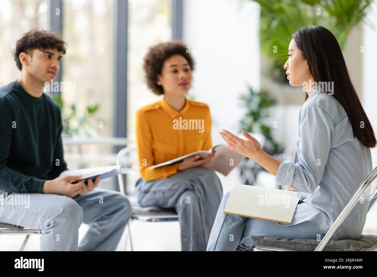 Diverse university students having a group discussion sitting together ...