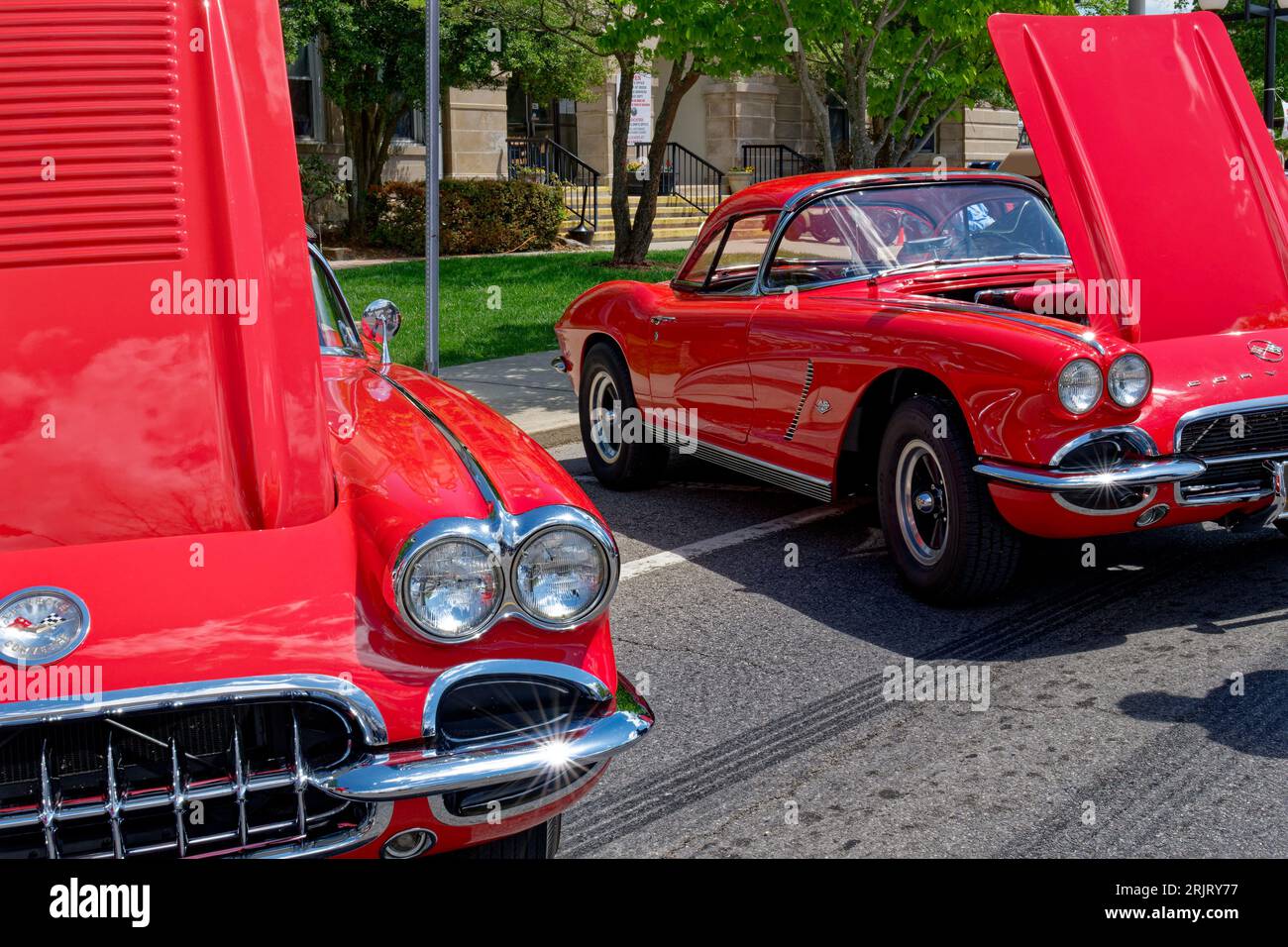 Partial view of two 1960's red Chevrolet Corvettes with the hoods up ...