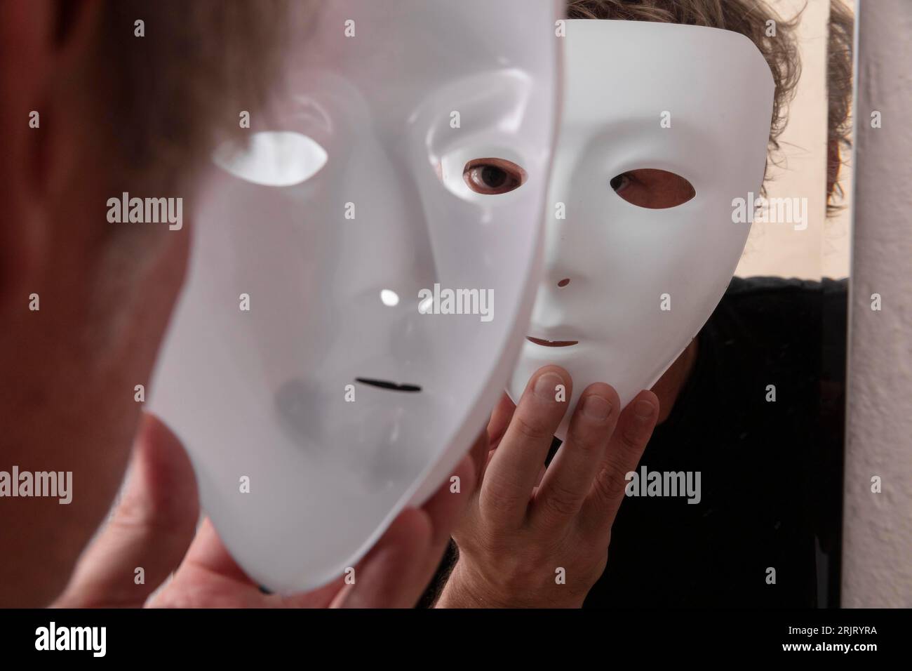 Self consideration through mask in a mirror Stock Photo - Alamy