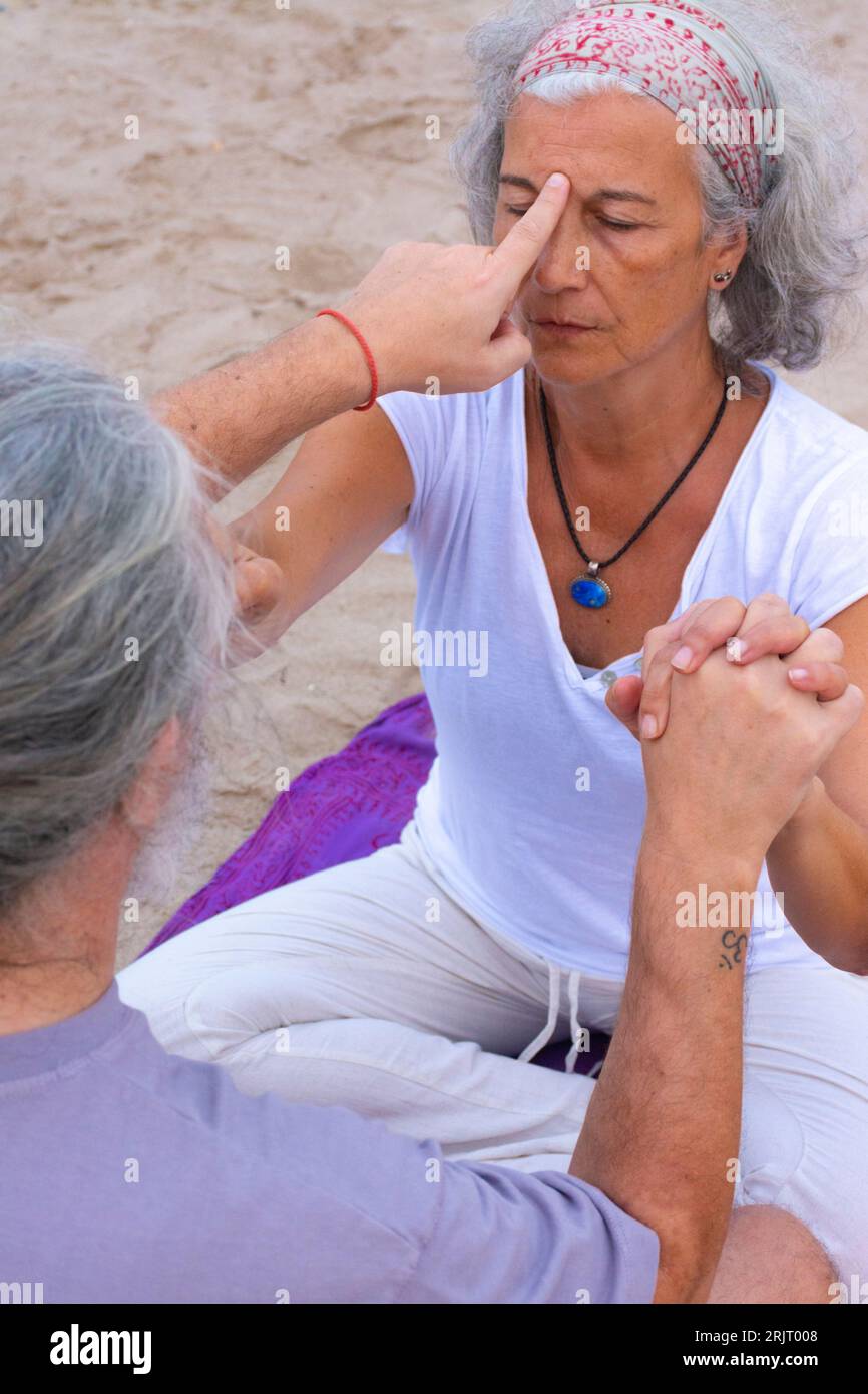 Couple meditating together in a sitting position favoring the personal ...