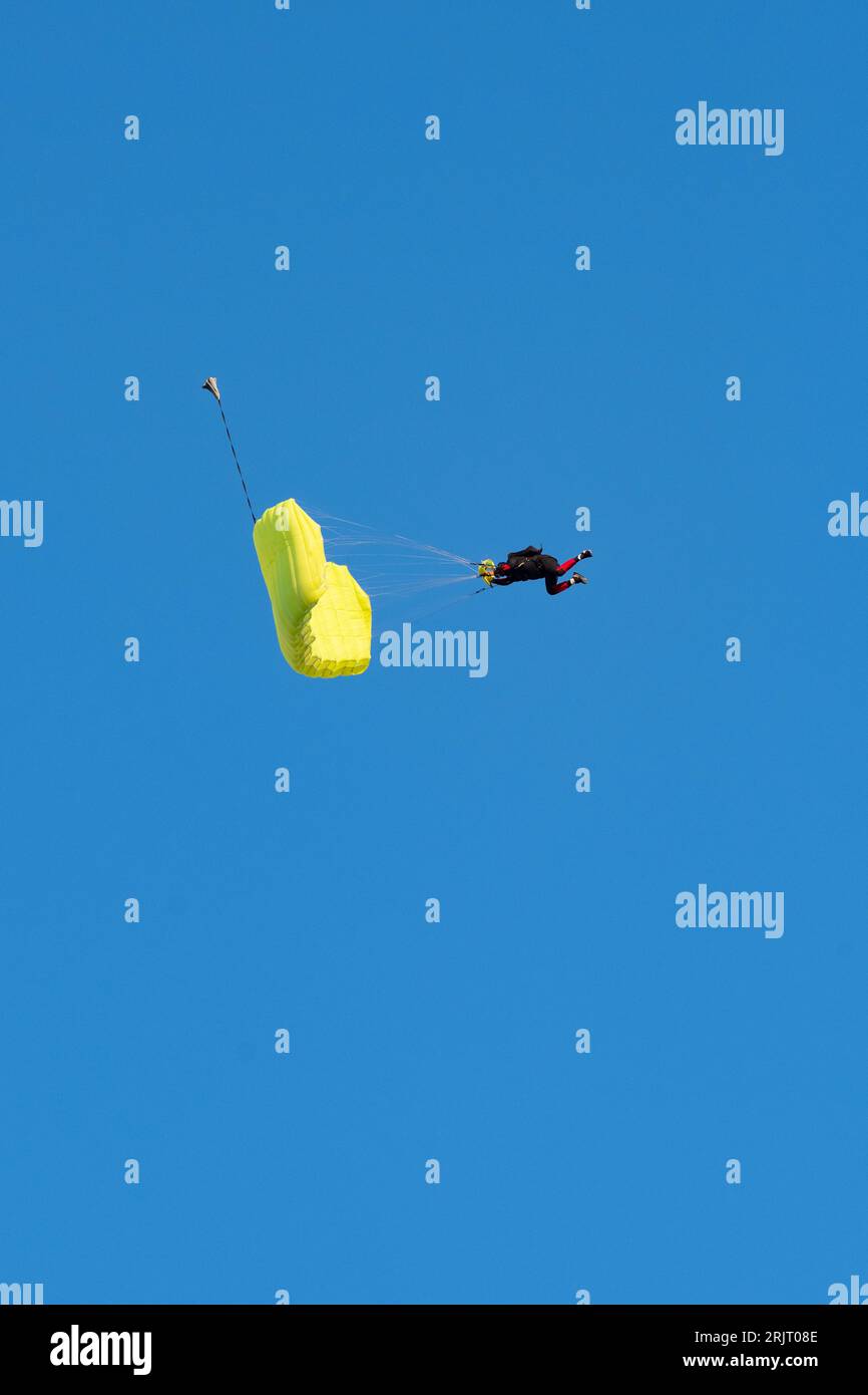 Stunning view of of a skydiver with a yellow parachute and a blue sky ...