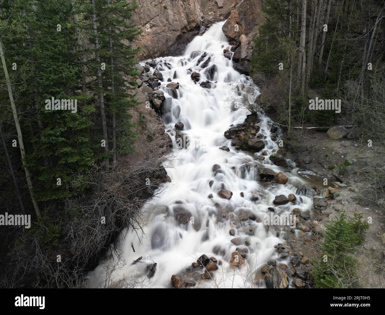 A majestic waterfall cascading down a rocky mountainside, surrounded by ...