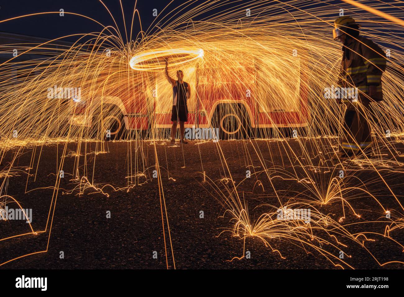 A vibrant steel wool display at night in front of a fire engine Stock ...
