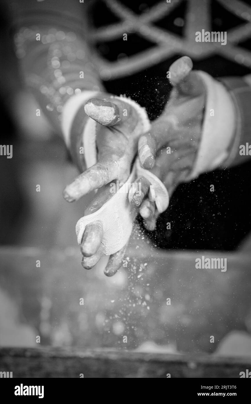 An image of a gymnast dusting their hands with chalk before a ...