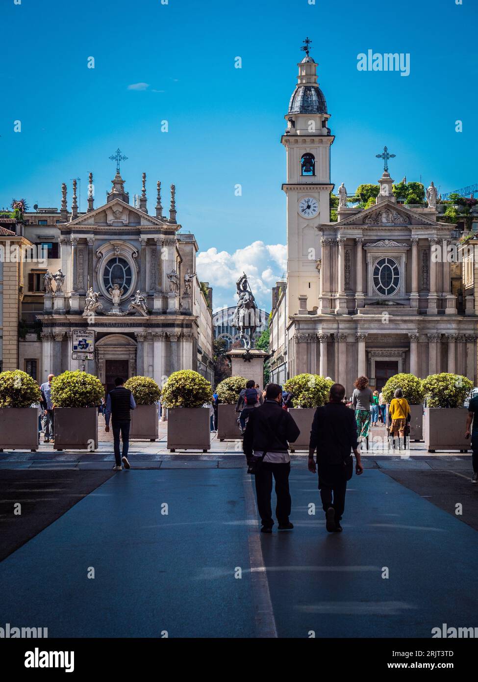 Photo of people walking down a street surrounded by towering buildings ...