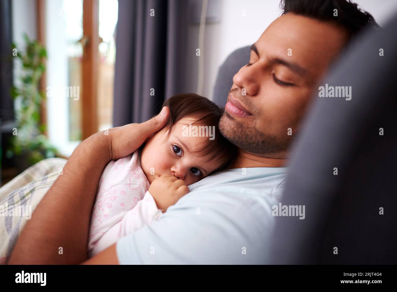 Affectionate father hugging his baby daughter at home Stock Photo - Alamy