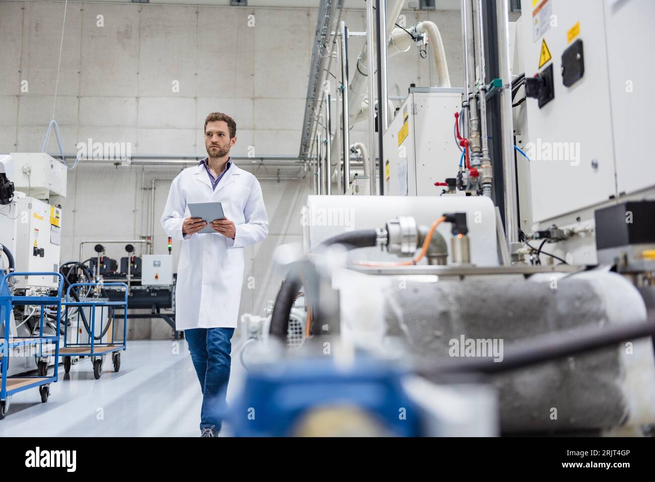 Employee checking manufacturing machines in high tech company, using ...