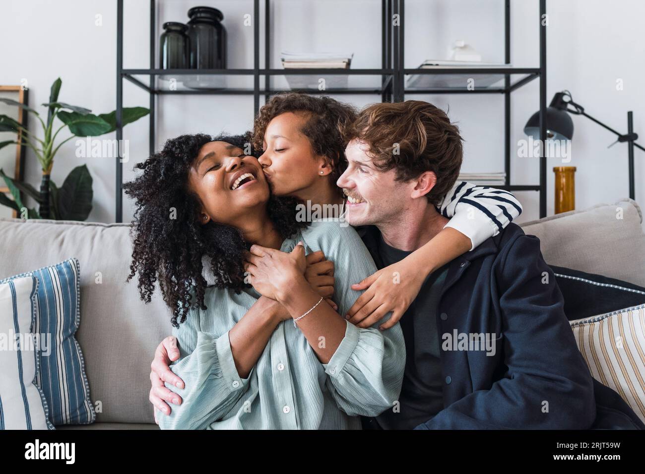 Happy family sitting on couch having fun at home Stock Photo - Alamy