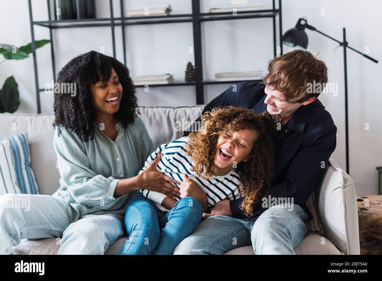 Happy family sitting on couch having fun at home Stock Photo - Alamy