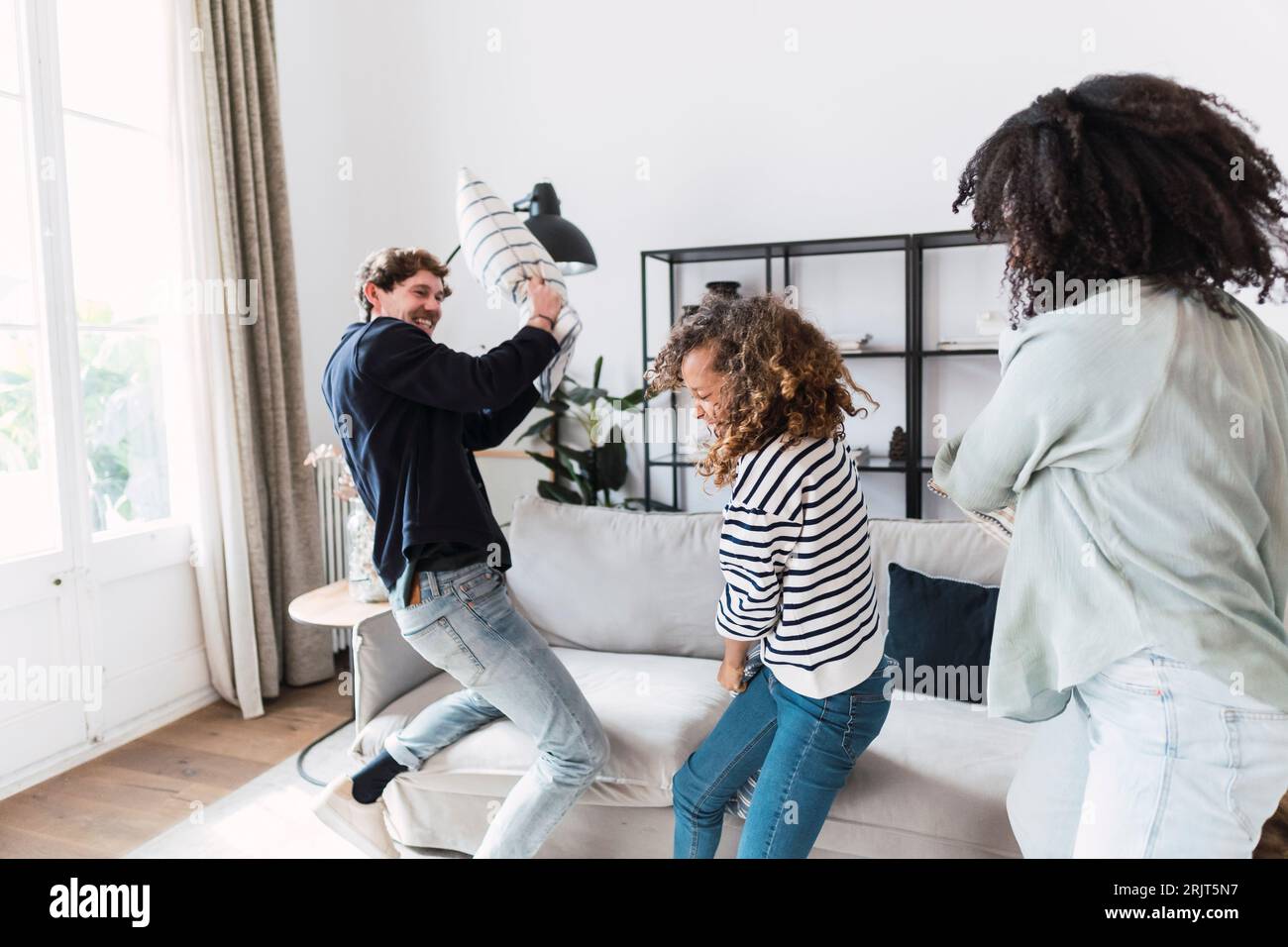 Lively family having fun with a pillow fight at home Stock Photo - Alamy