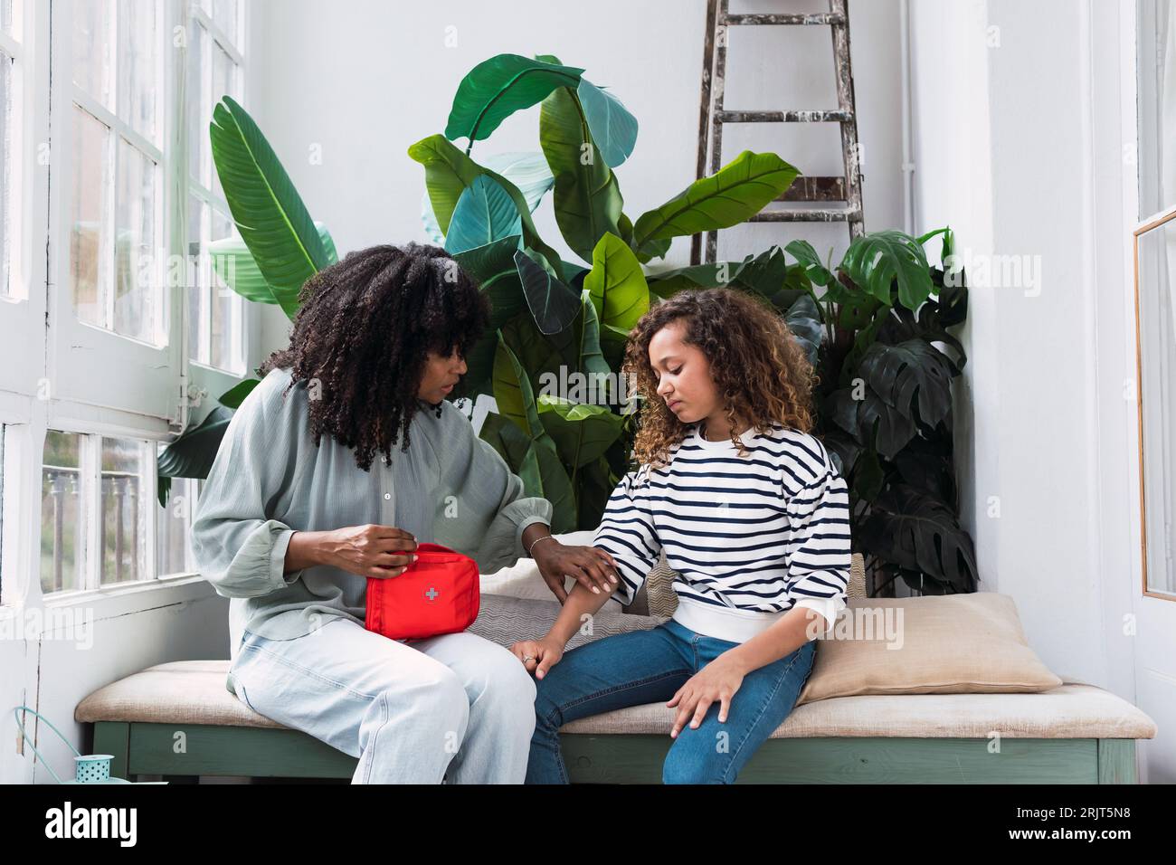 Mother with first aid kit taking care of injured daughter Stock Photo ...