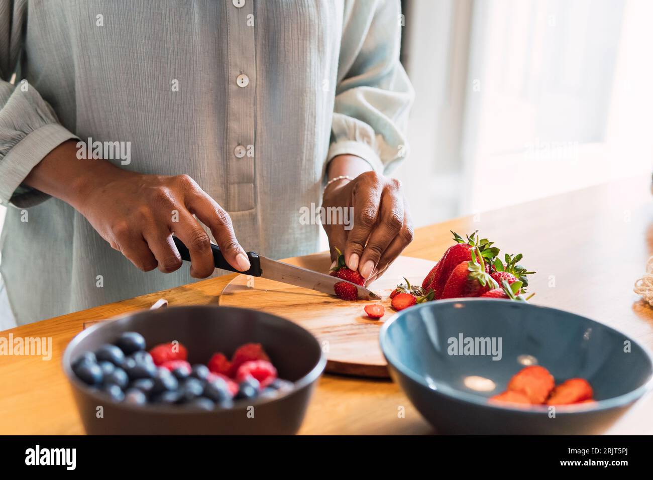 Woman standing at kitchen counter chopping healthy food Stock Photo - Alamy