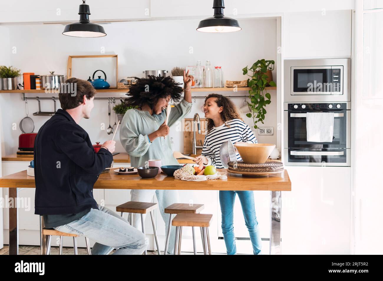 Happy family preparing food together singing and dancing in the kitchen ...