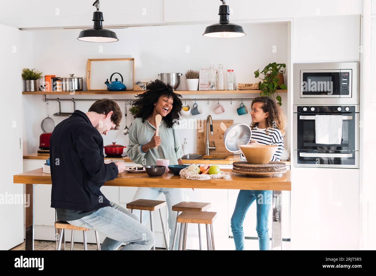 Happy family preparing food together singing and dancing in the kitchen ...