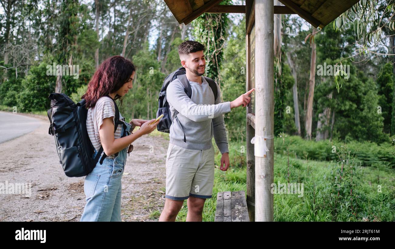 Man pointing at map standing with girlfriend using smart phone Stock ...