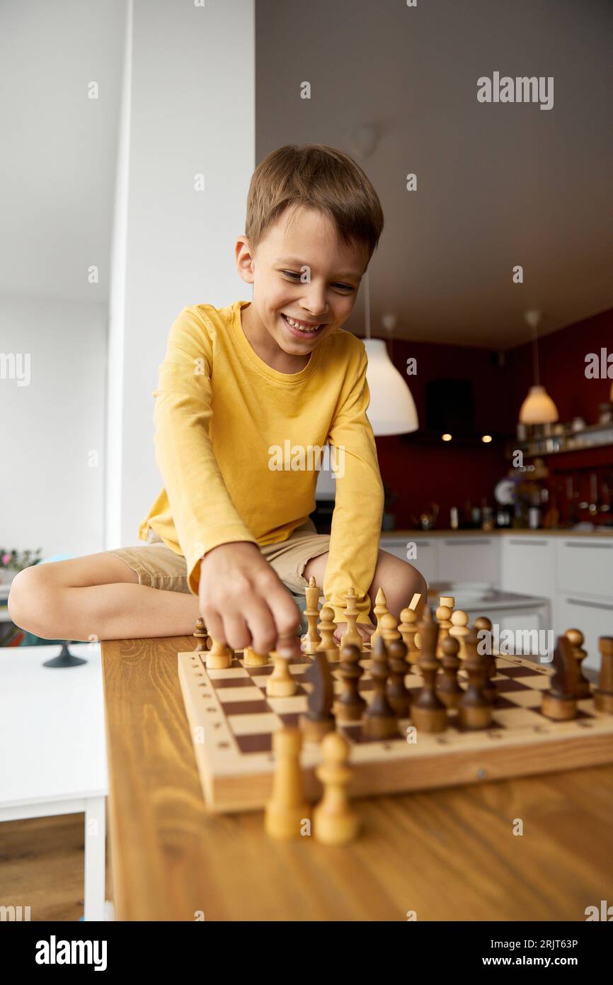 Happy boy playing chess at home Stock Photo - Alamy