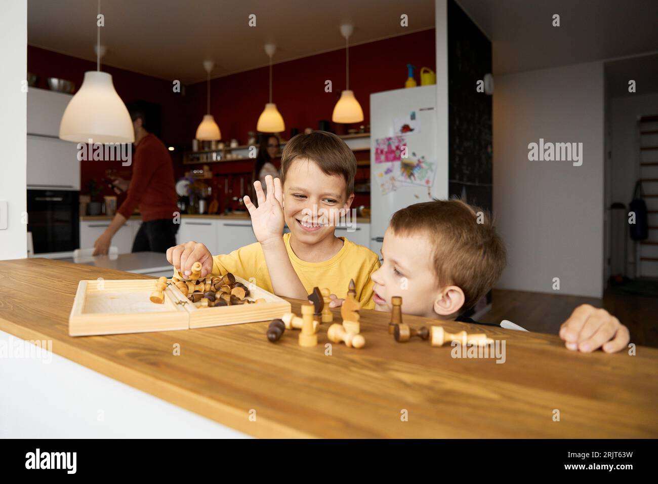 Happy boy playing chess with brother at home Stock Photo - Alamy
