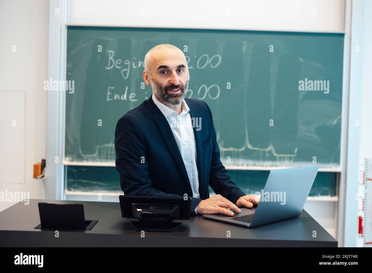 Portrait happy professor sitting desk hi-res stock photography and ...