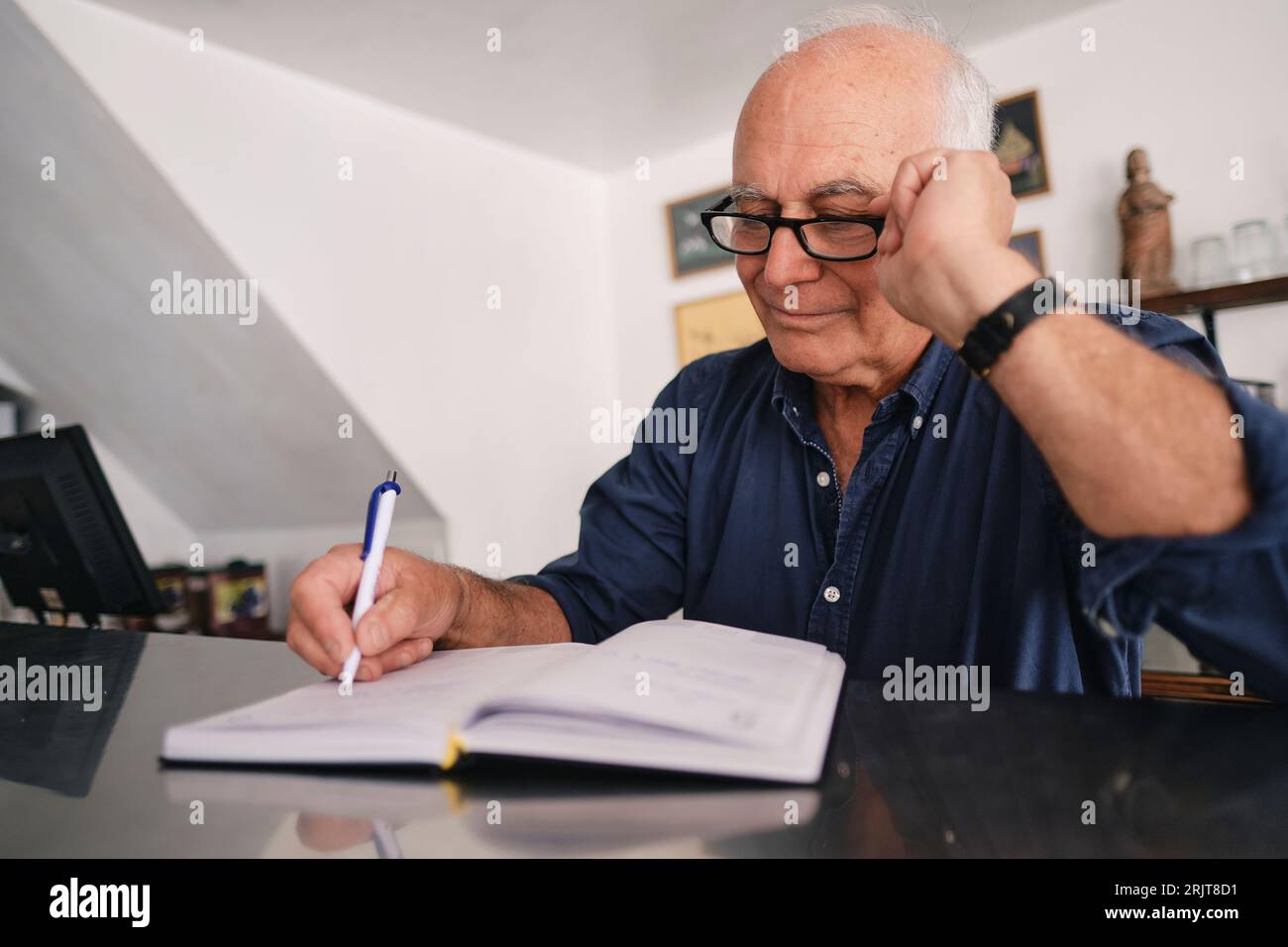 Smiling cafe owner wearing eyeglasses writing in diary Stock Photo - Alamy