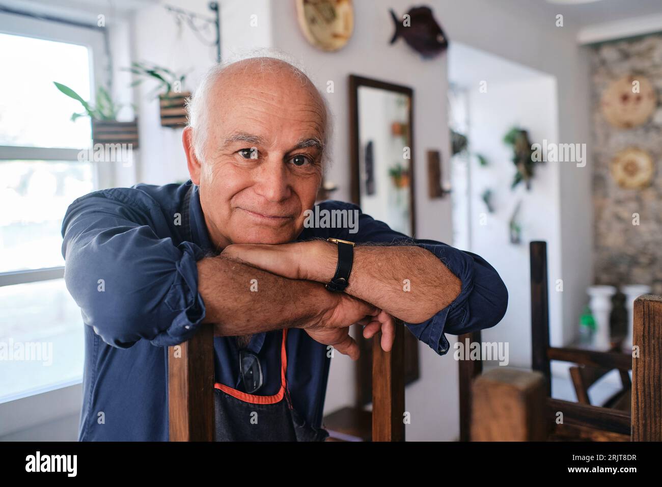 Thoughtful senior cafe owner leaning on backrest in coffee shop Stock ...