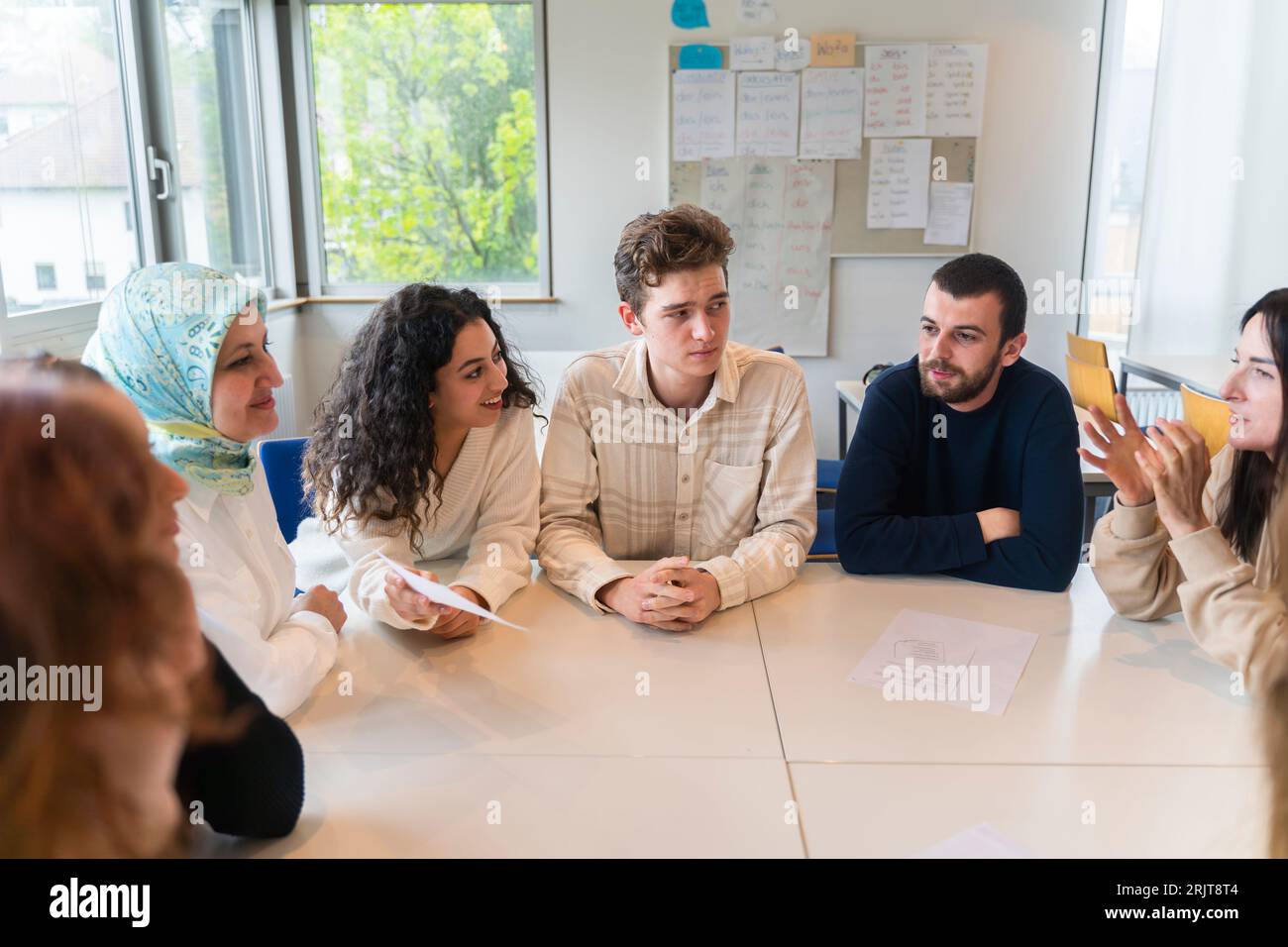 Students having discussion sitting around table in classroom Stock ...